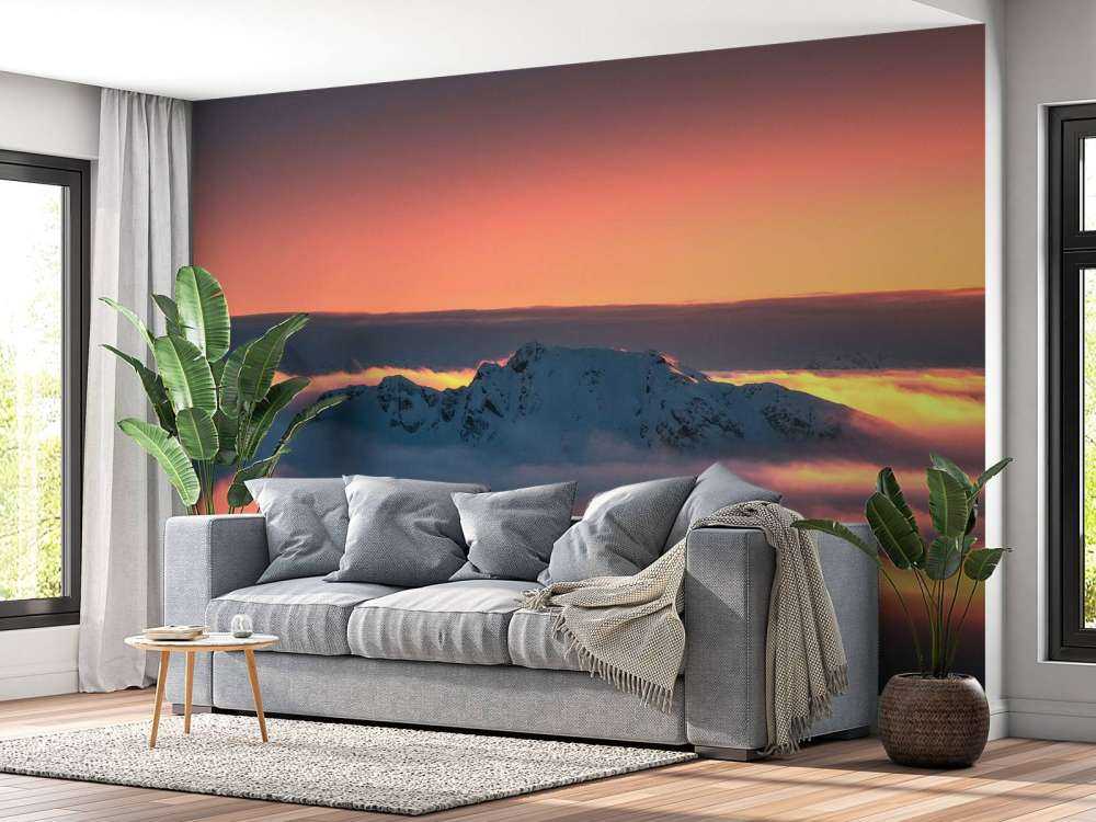 Fotobehang - Besneeuwde bergtop in wolkenzee - Fotobehang