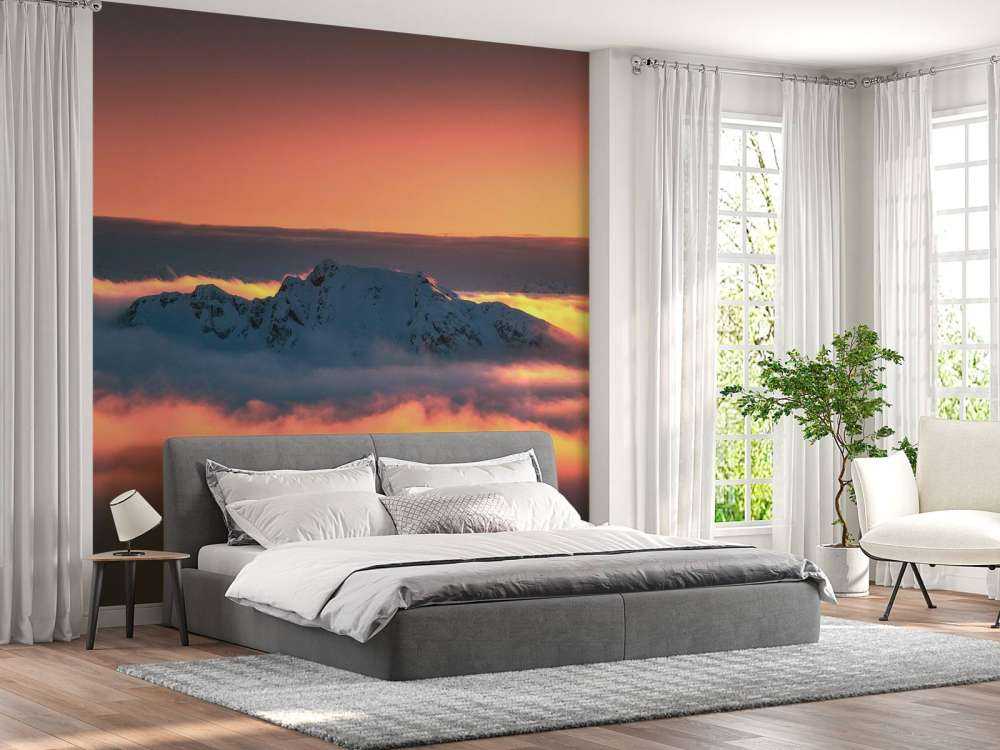 Fotobehang - Besneeuwde bergtop in wolkenzee - Fotobehang