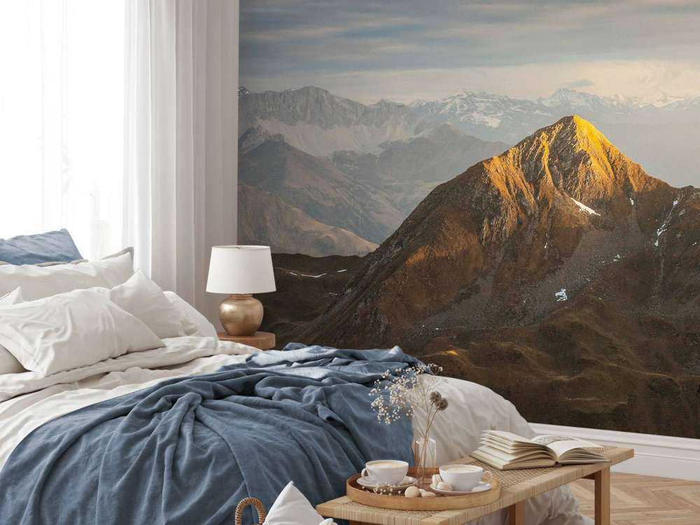 Fotobehang - Gouden zonlicht op bergtop bij zonsopkomst - Fotobehang